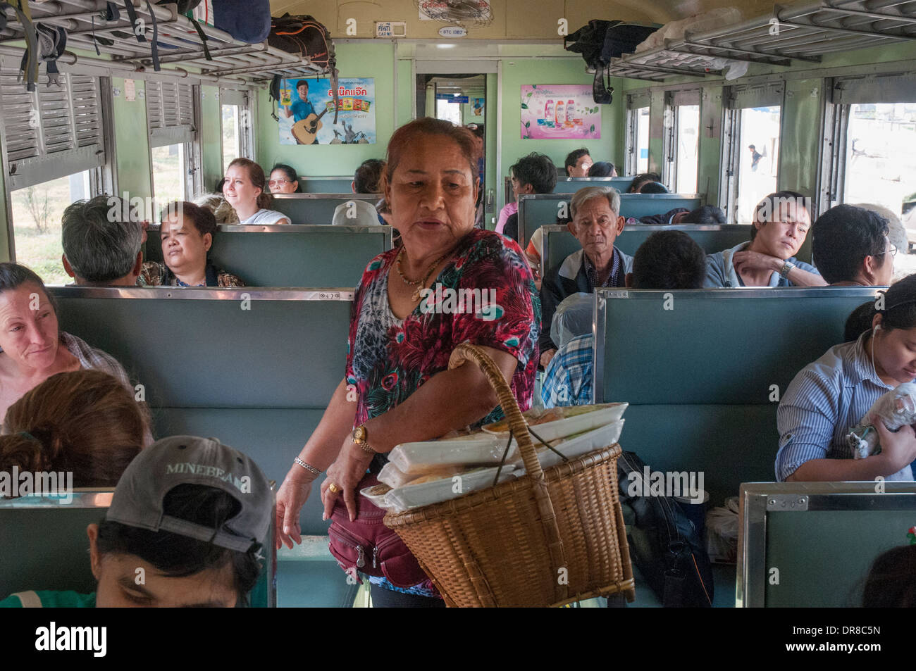Vendor selling food aboard a third-class local train from Bangkok to ...