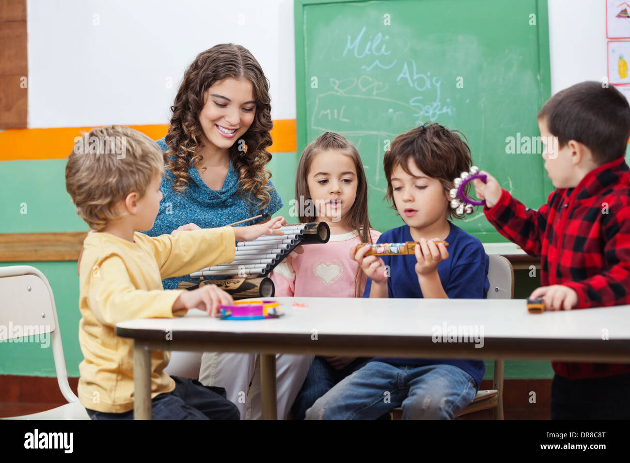 Children And Teacher Playing With Musical Instruments Stock Photo - Alamy