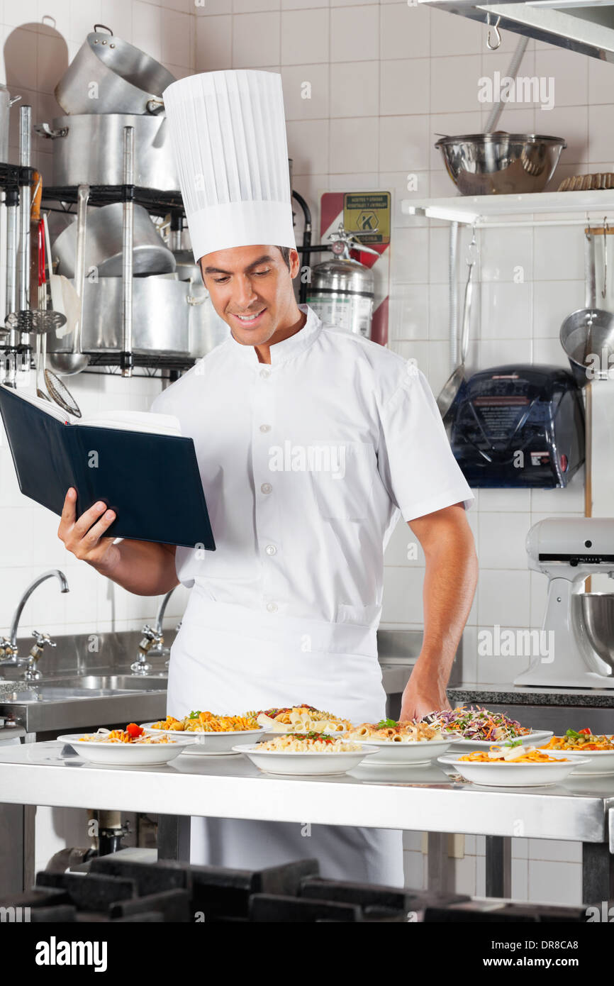 Chef With Checklist And Pasta Dishes At Counter Stock Photo - Alamy