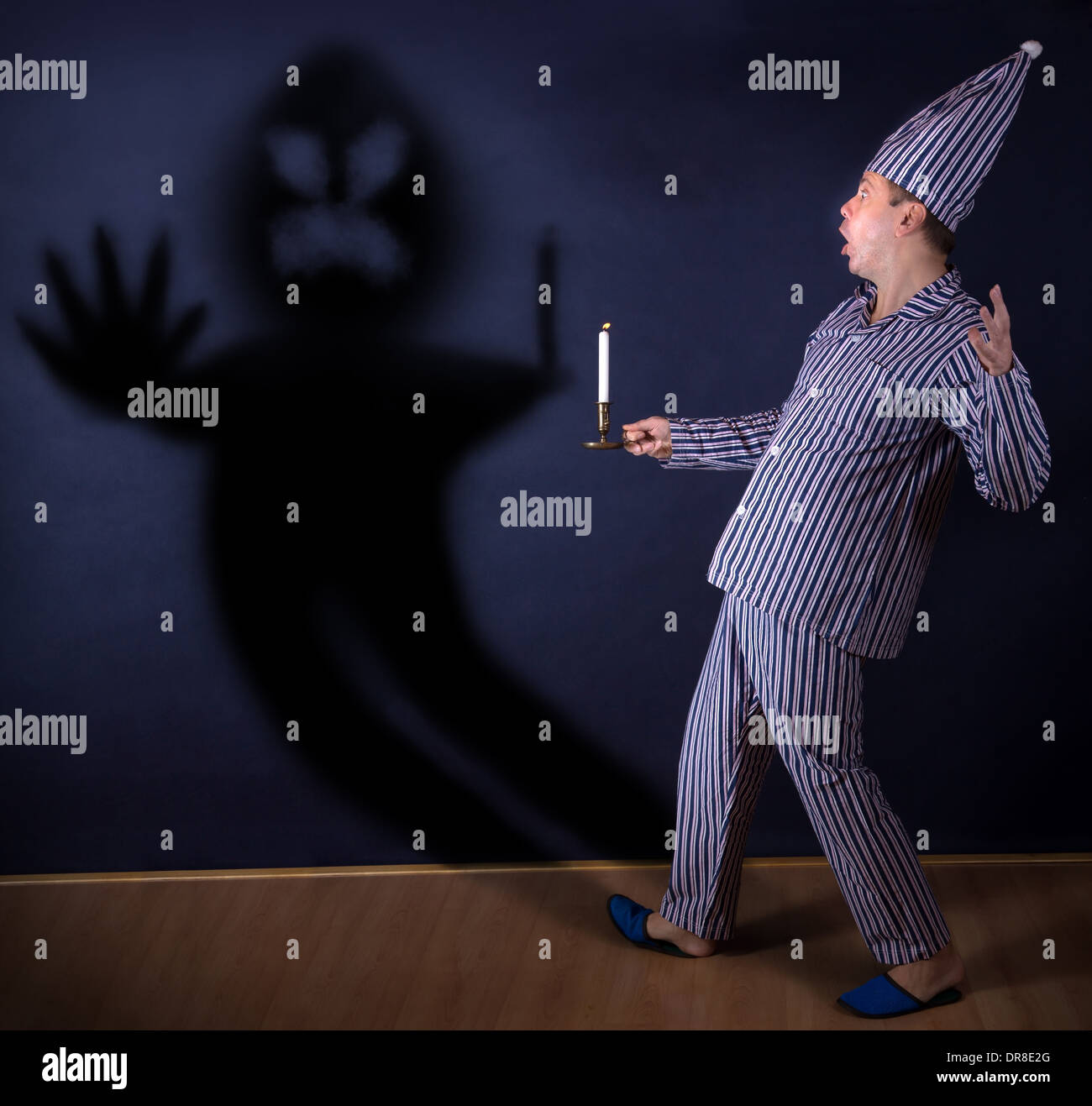 frightened man with candle in pajamas Stock Photo - Alamy