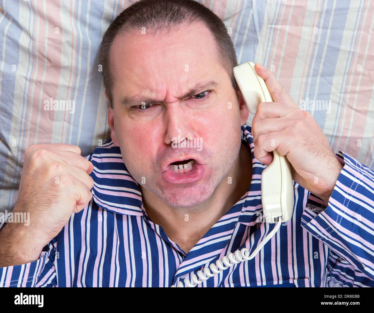 angry man with phone in bed Stock Photo - Alamy