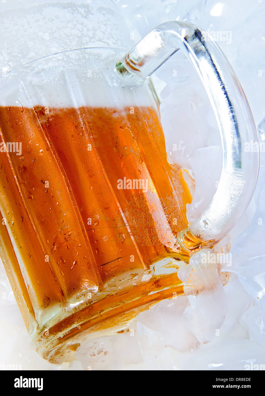 Glass of cold beer lying in the ice Stock Photo - Alamy