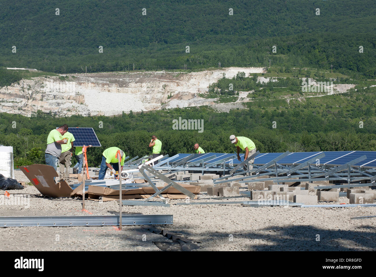 Workers among solar panes near the completion of installation in Adams ...