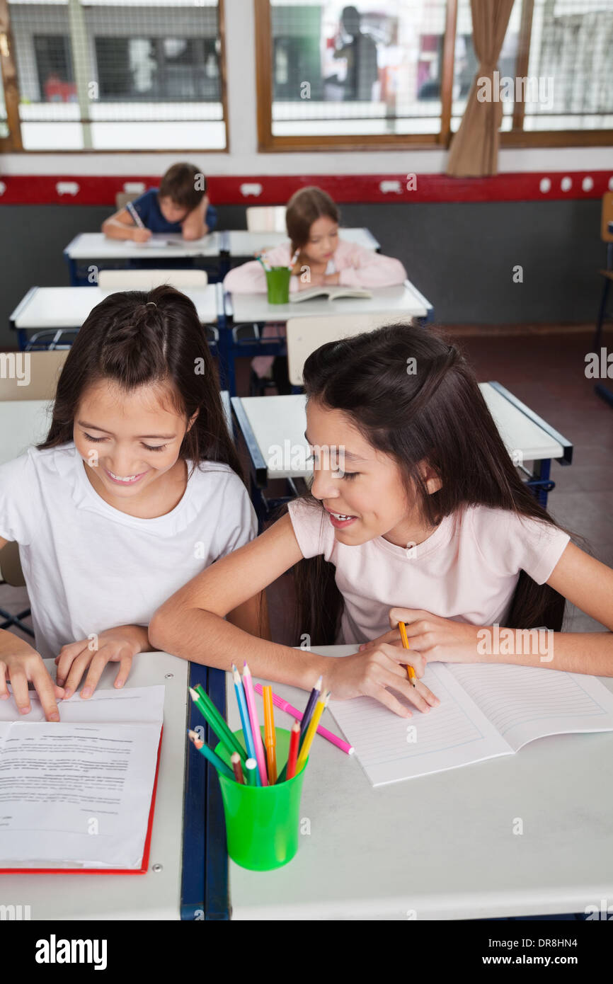 Schoolgirls Studying Together In Classroom Stock Photo - Alamy