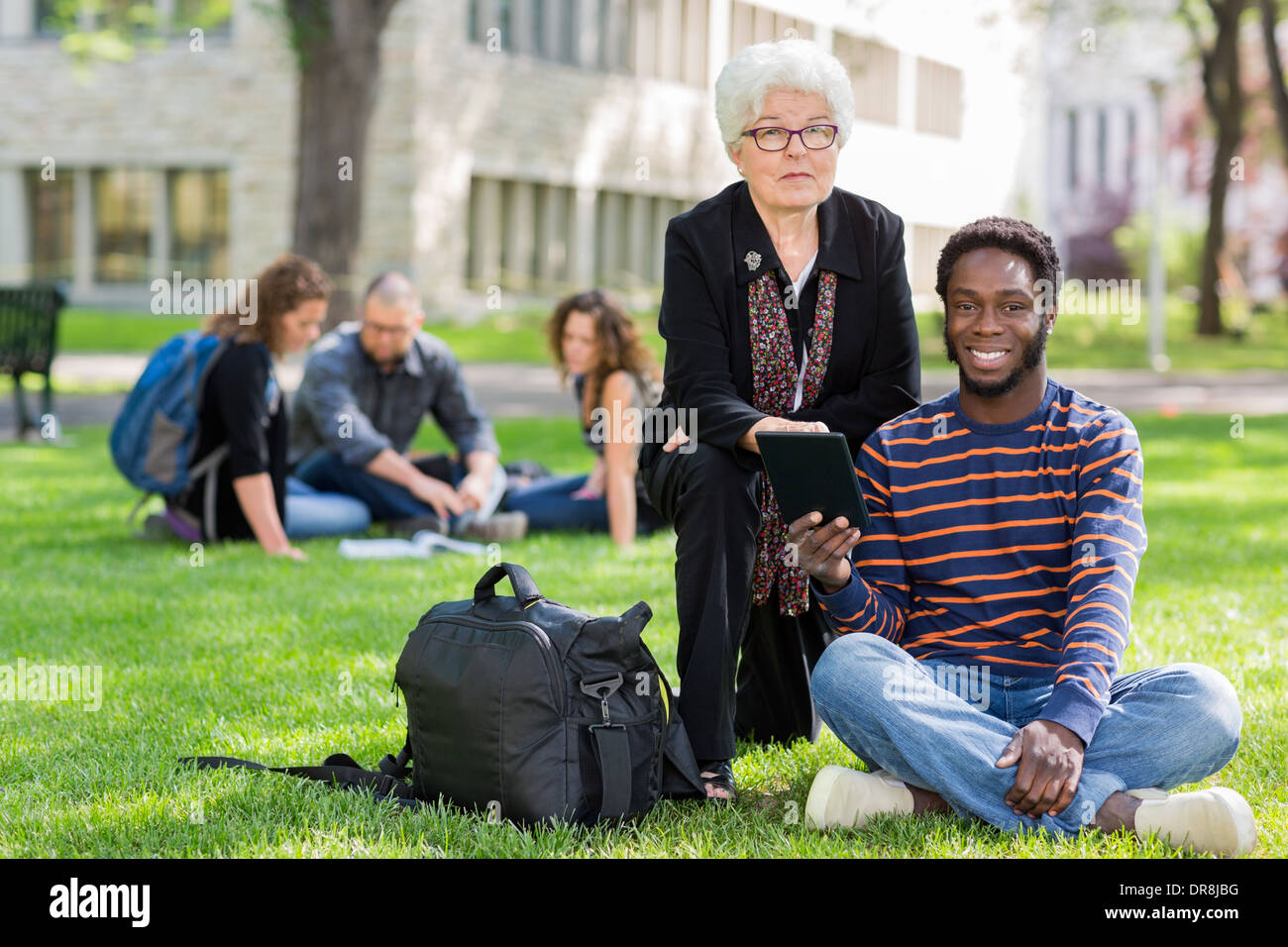 Professor Helping Student on Digital Tablet Stock Photo - Alamy