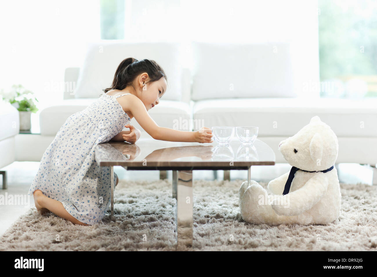 a kid with a teddy bear on the other end of table Stock Photo - Alamy