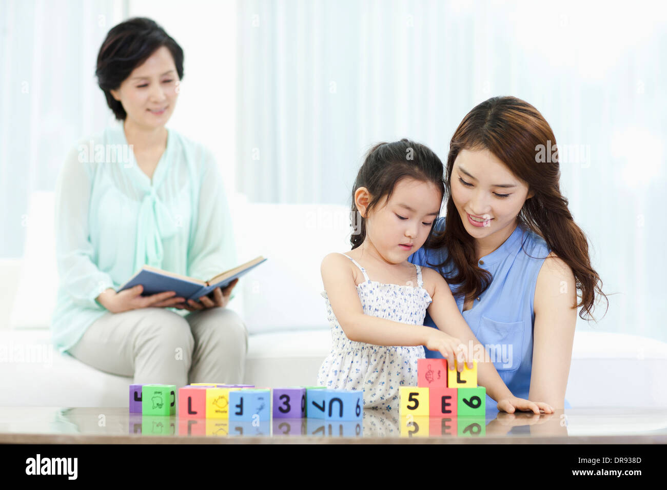 a woman watching daughter and grand daughter playing together Stock Photo - Alamy