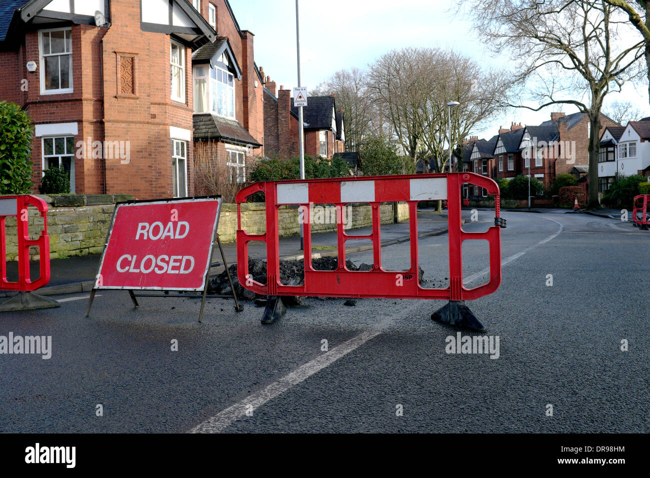 a sign and barrier on a street to prevent entry while it is being ...