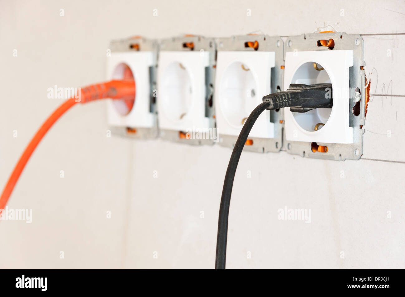 Sockets in a cyproc wall and two plugs are in it Stock Photo - Alamy