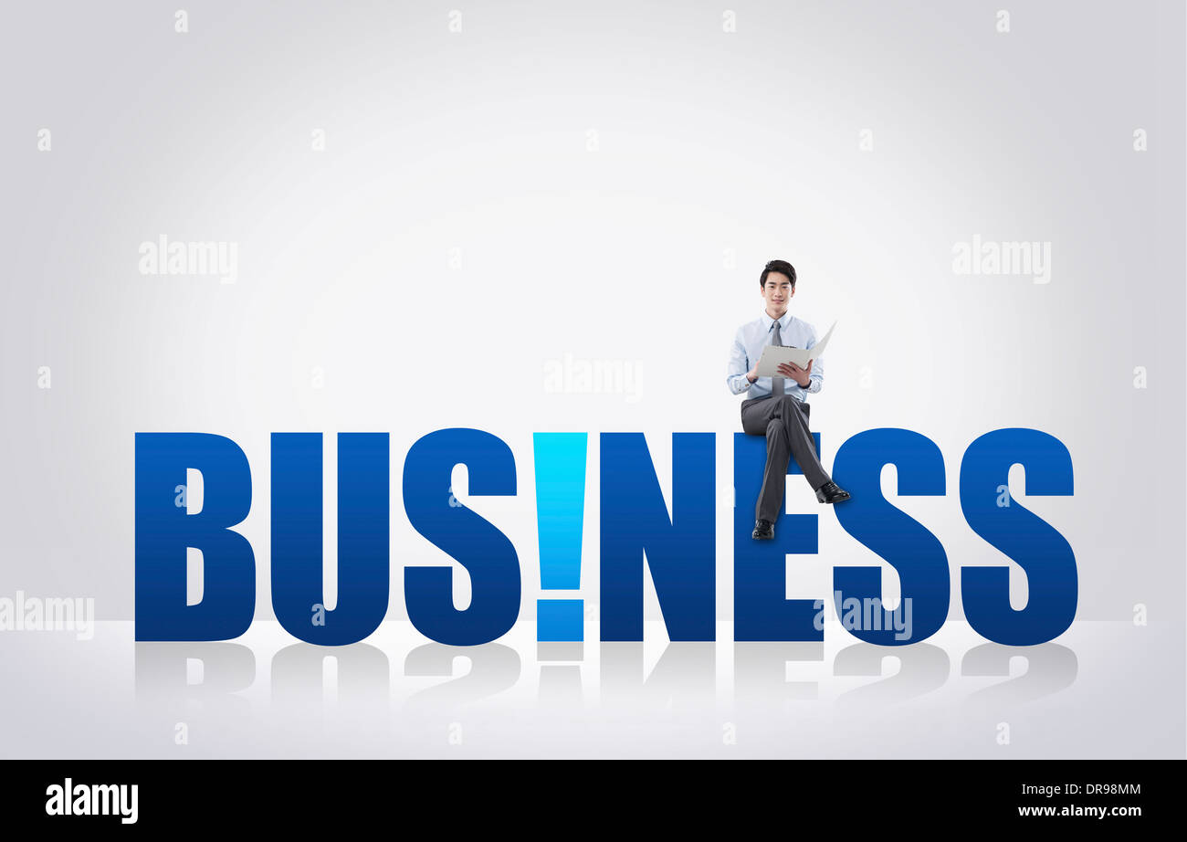 a business man sitting on the word business Stock Photo - Alamy