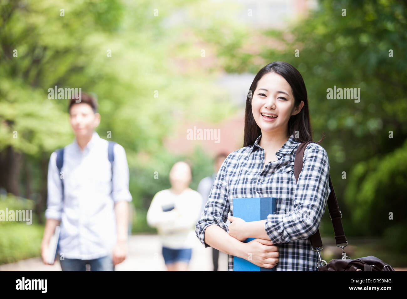 a university student standing in the campus holding books Stock Photo ...