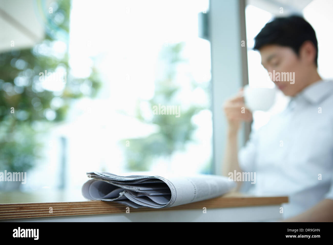 a man with a white shirt behind a newspaper Stock Photo - Alamy