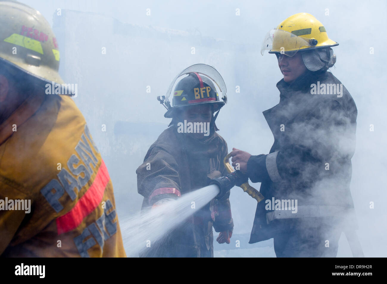 Pasay City, Philippines-January 22, 2014: Fire fighters putting off the ...