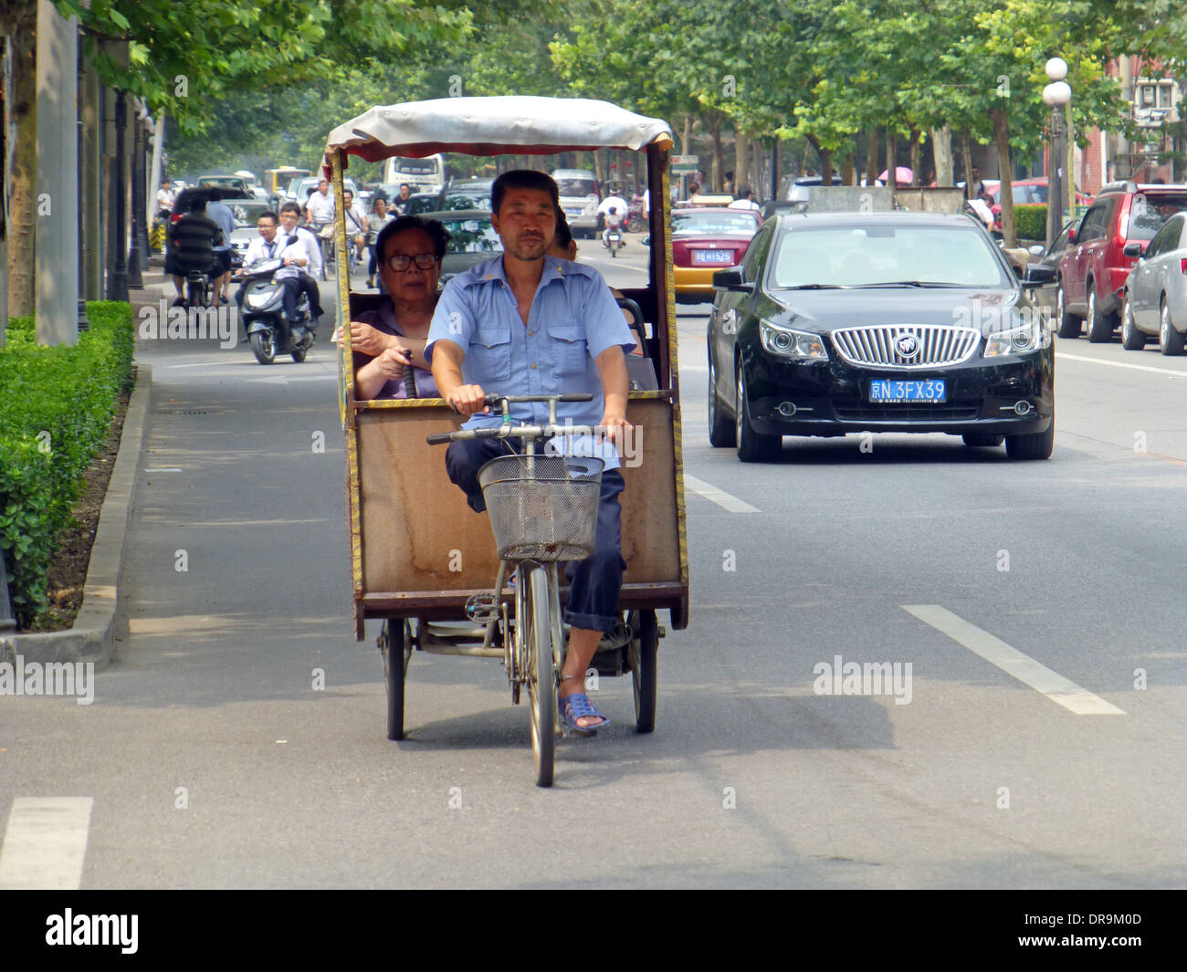 rickshaw bike traveling on a busy street with cars Stock Photo - Alamy