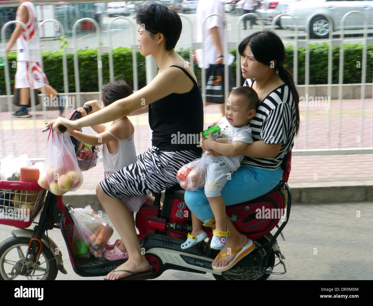 two women and two children on moped in China Stock Photo - Alamy