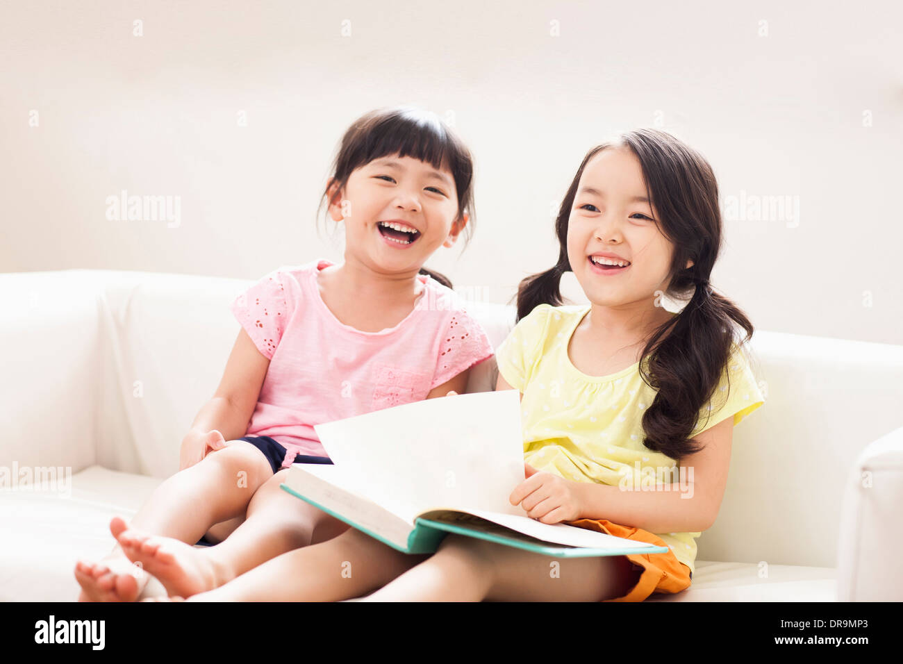 two girls reading a book Stock Photo - Alamy