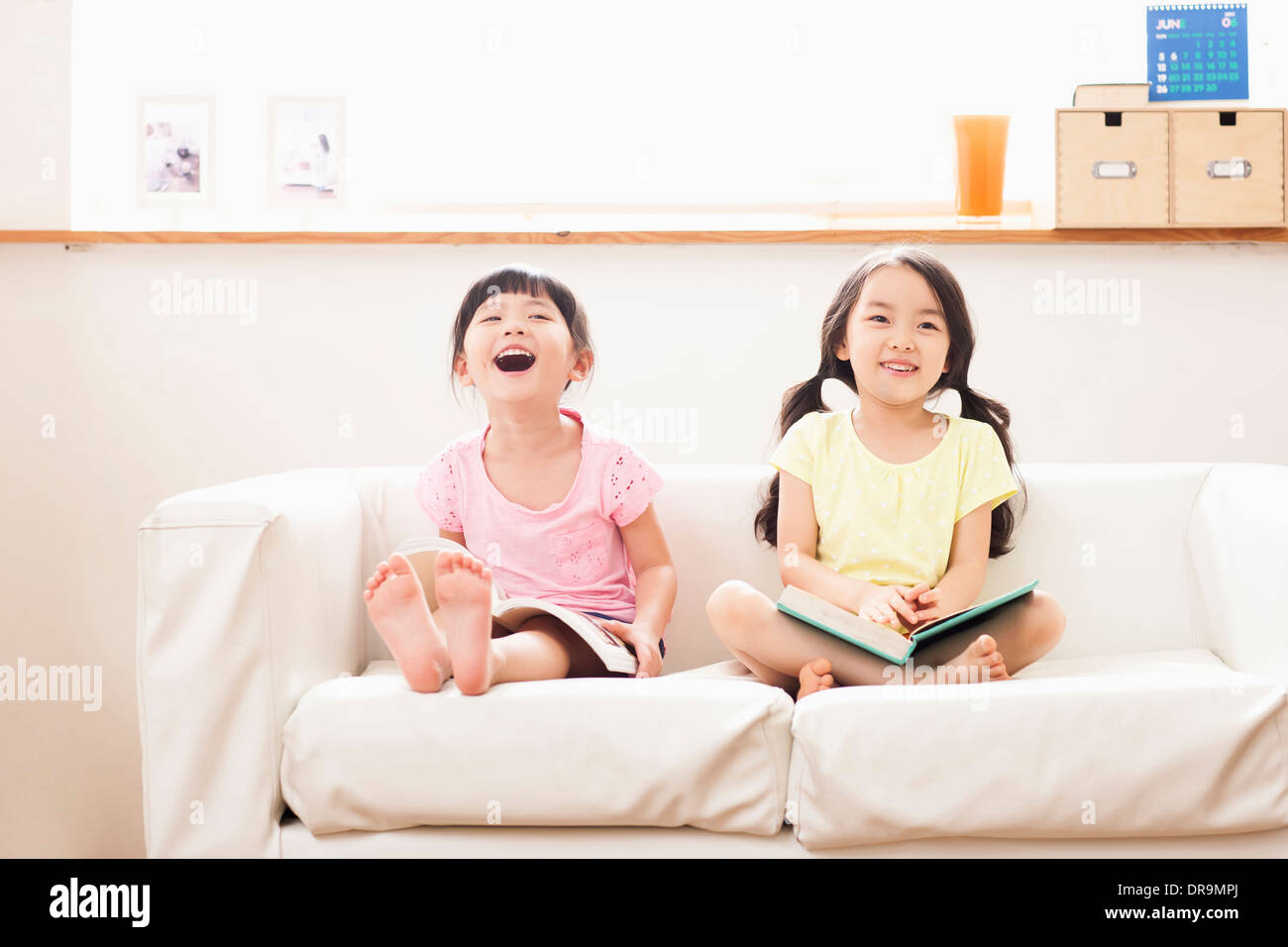 two girls reading a book Stock Photo - Alamy