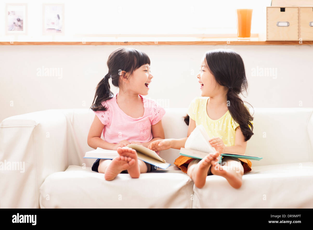 two girls reading a book Stock Photo - Alamy