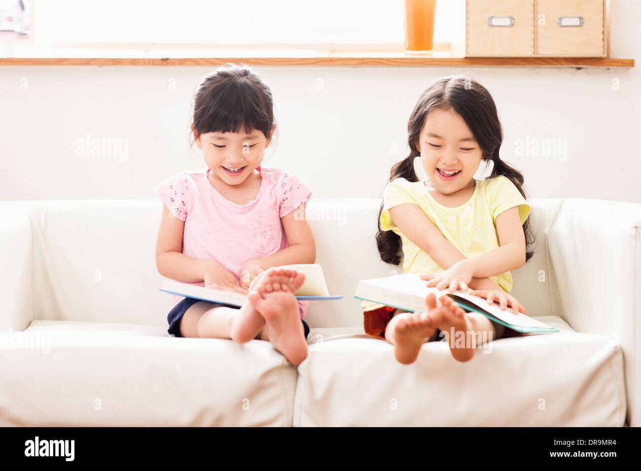 two girls reading a book Stock Photo - Alamy