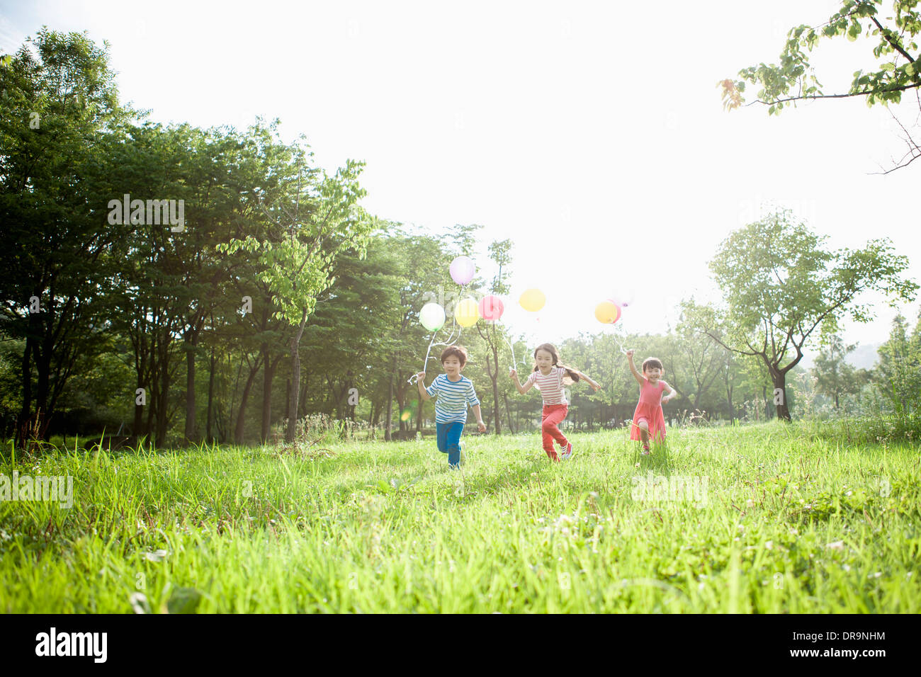 Smiling children balloons running hi-res stock photography and images ...