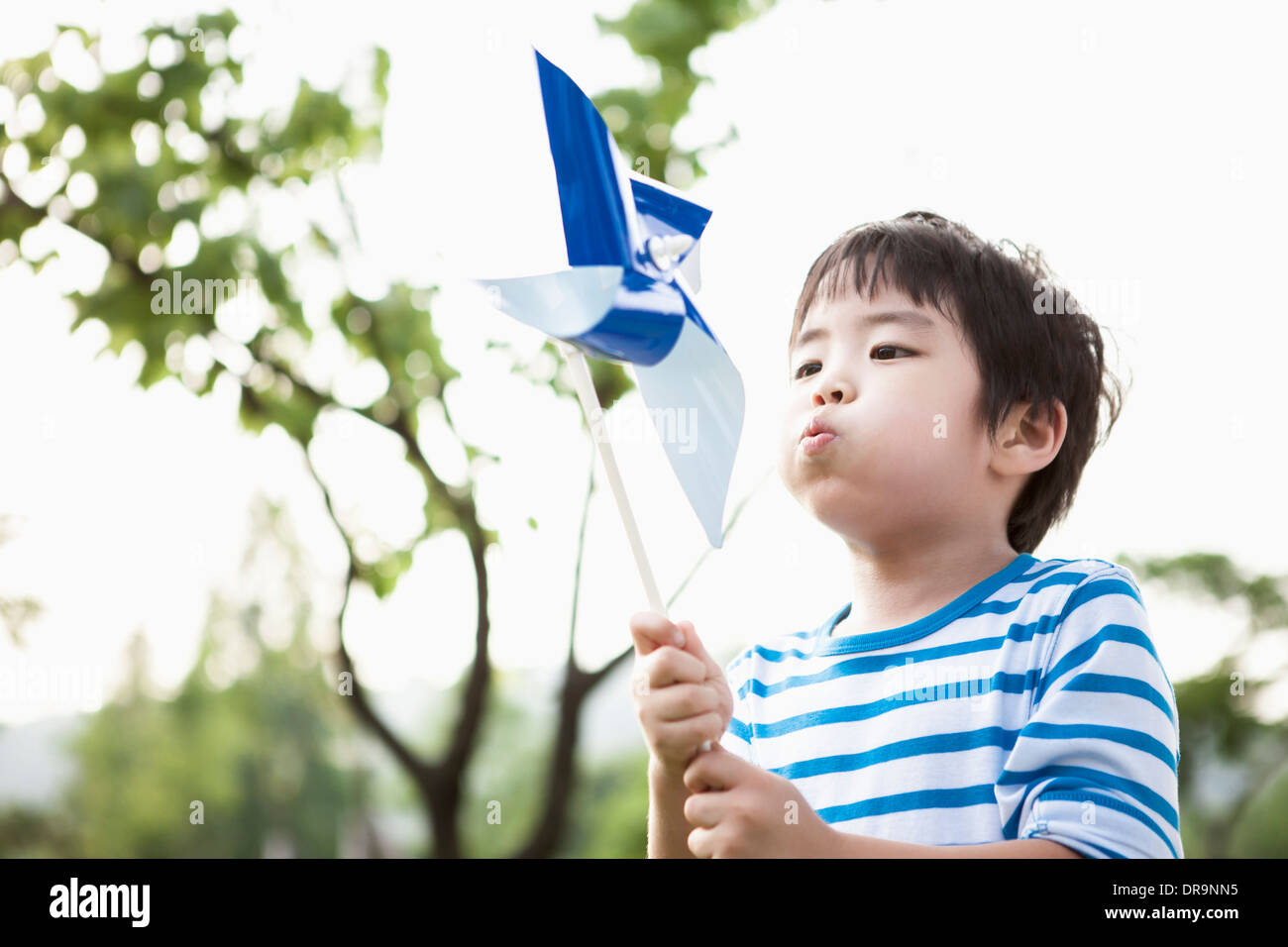 a boy playing with a toy wind mill Stock Photo - Alamy