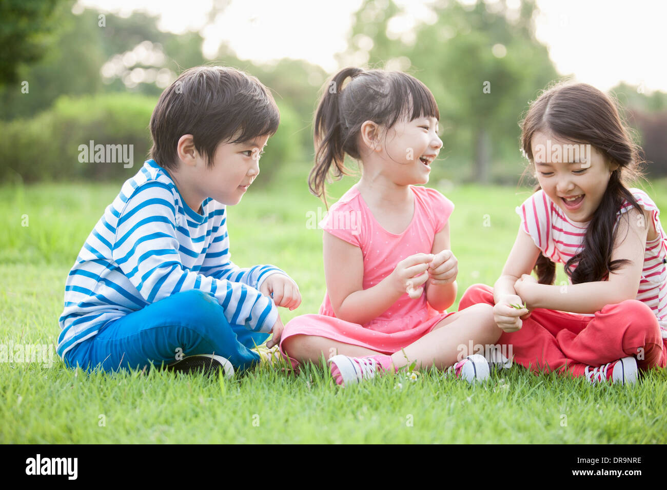 kids sitting on the grass Stock Photo - Alamy