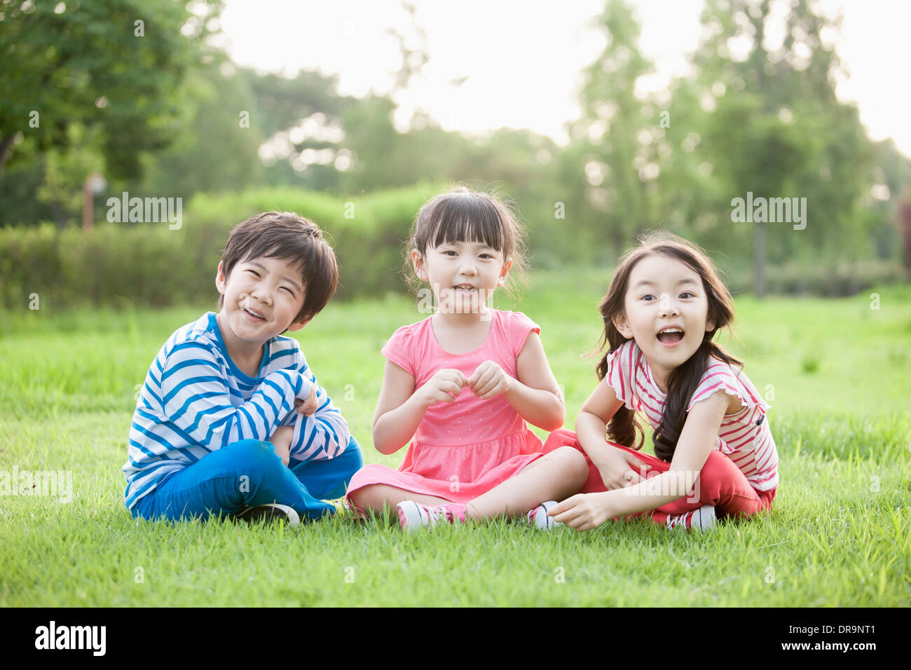 kids sitting on the grass Stock Photo - Alamy