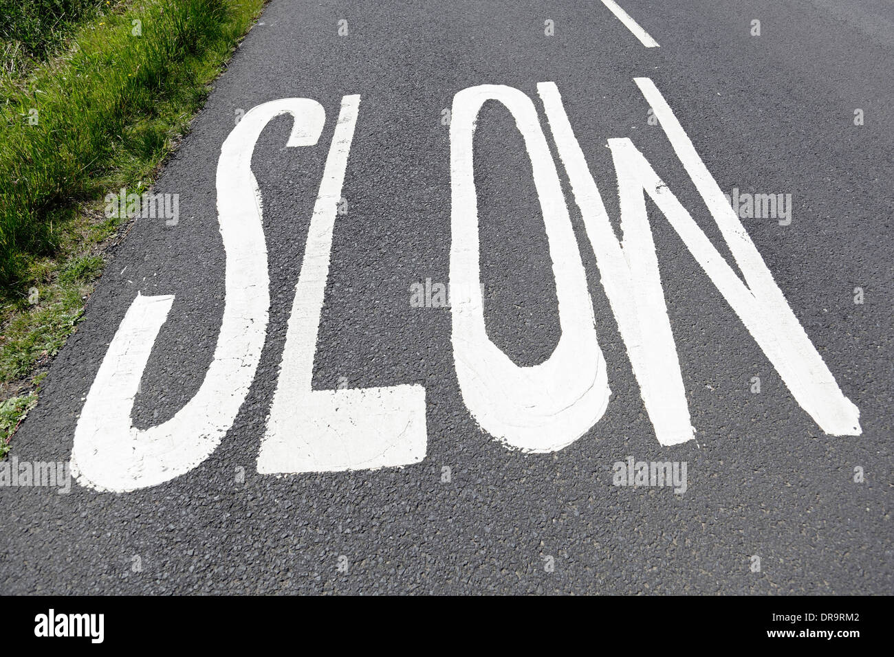 A Slow sign painted on a road, UK Stock Photo - Alamy
