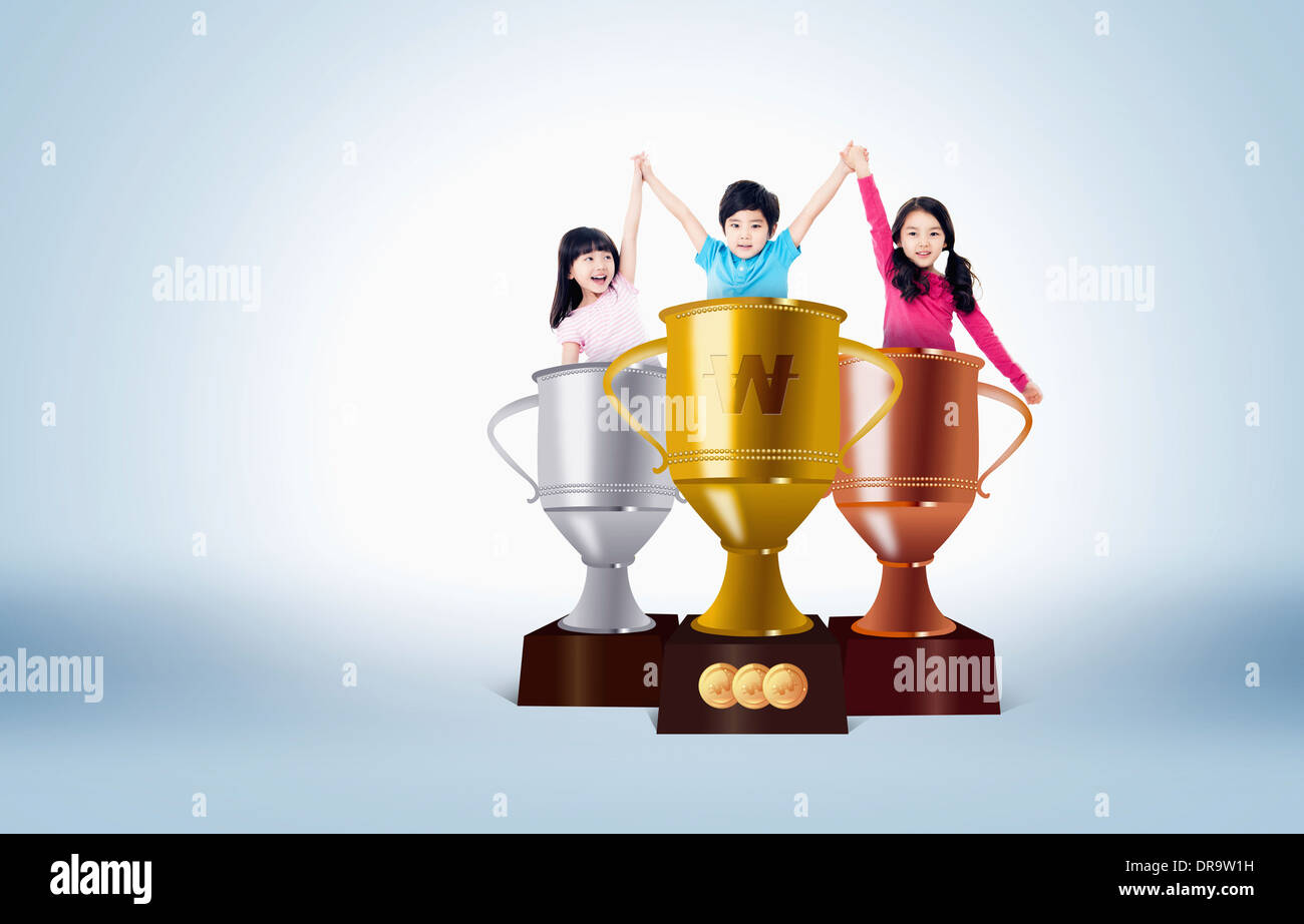 kids raising their hands while standing inside trophies Stock Photo - Alamy