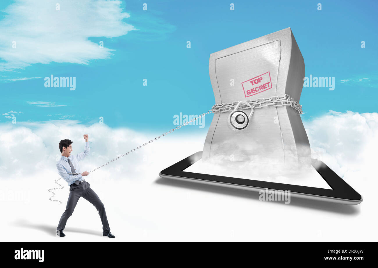 a businessman pulling safe with a chain Stock Photo - Alamy