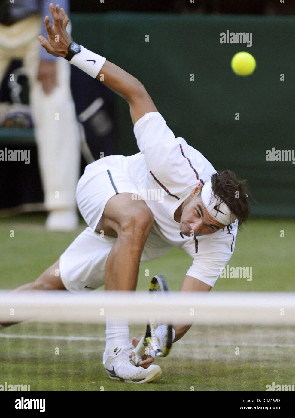 Rafael Nadal of Spain loses his balance while trying to play a return ...