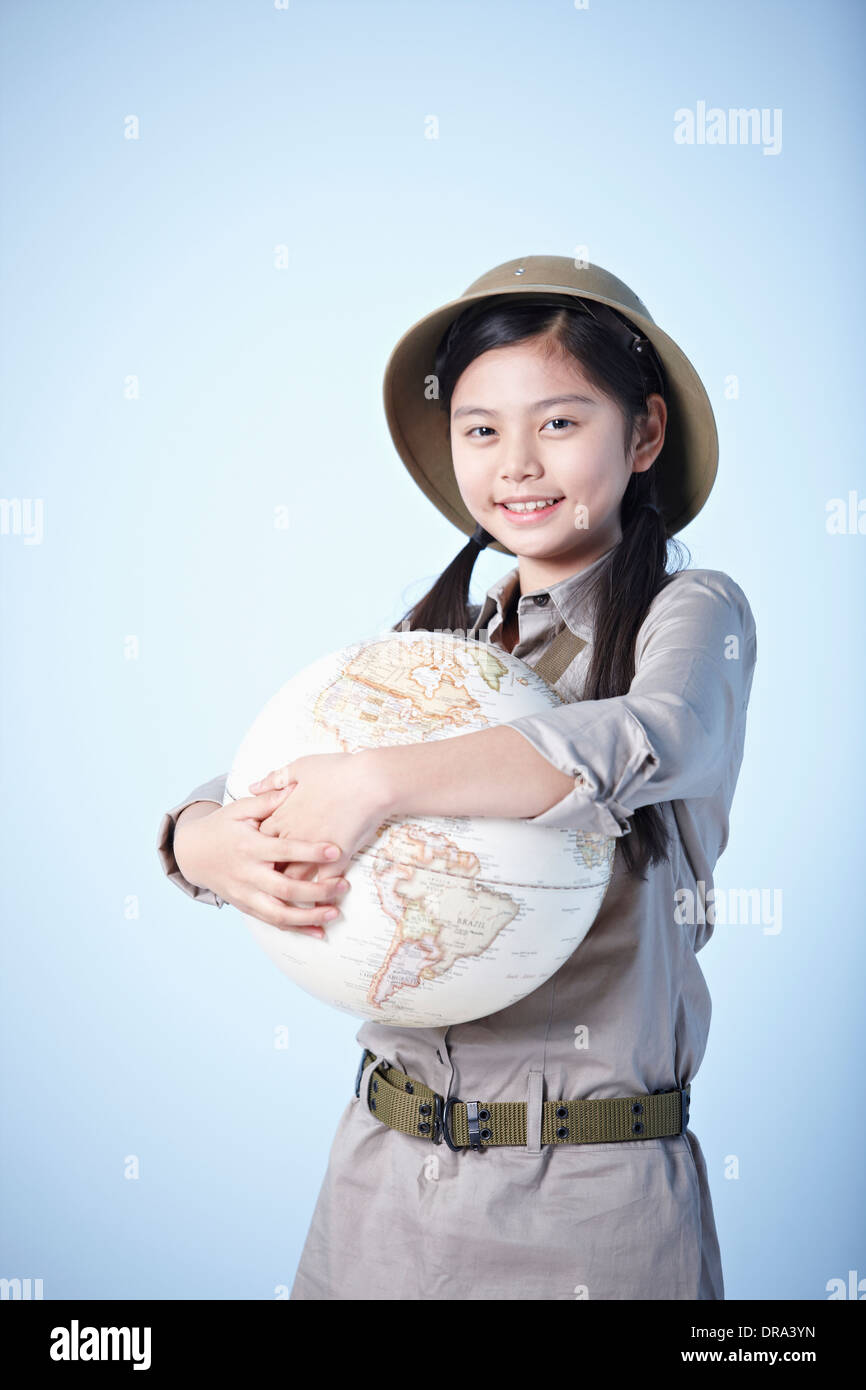 a girl holding a globe dressed as an explorer Stock Photo - Alamy