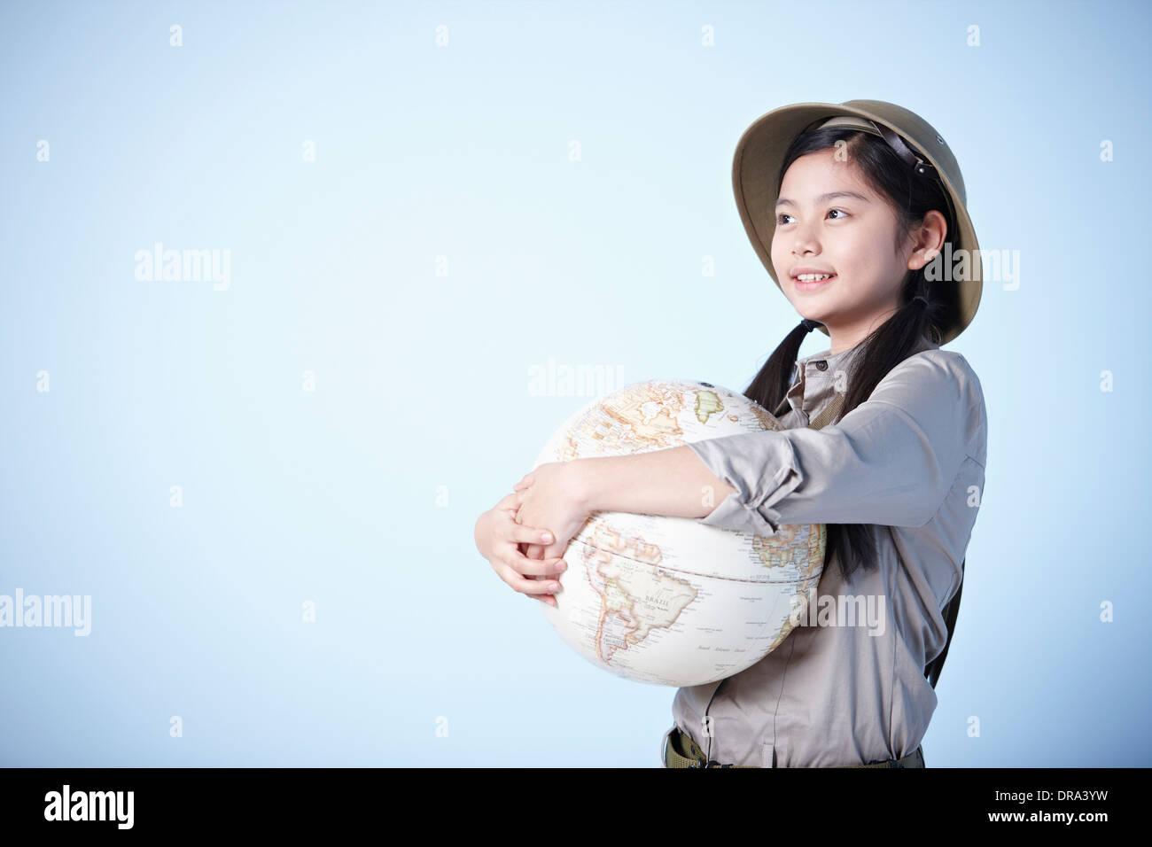 a girl holding a globe dressed as an explorer Stock Photo - Alamy