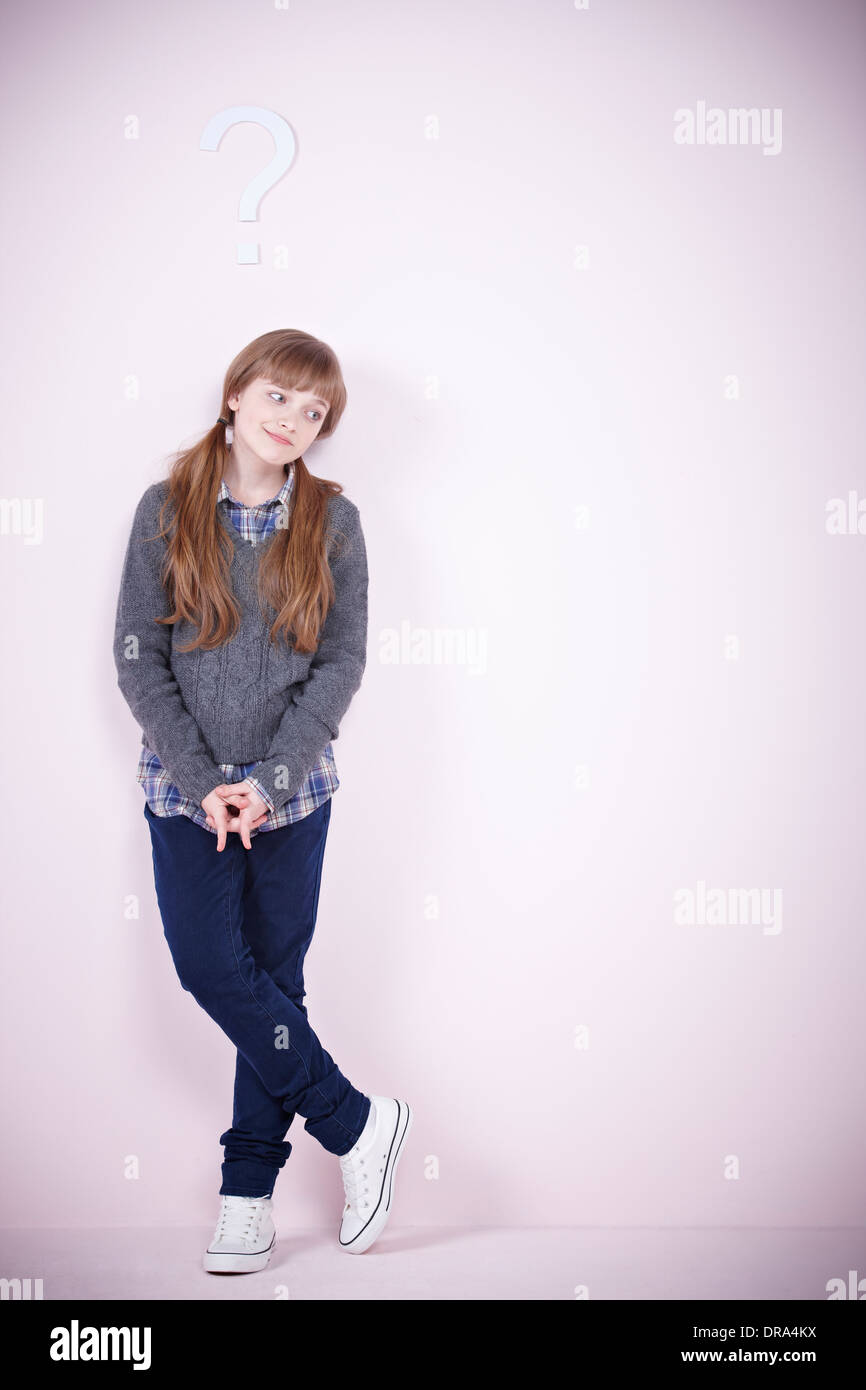 a girl standing under a question mark Stock Photo - Alamy