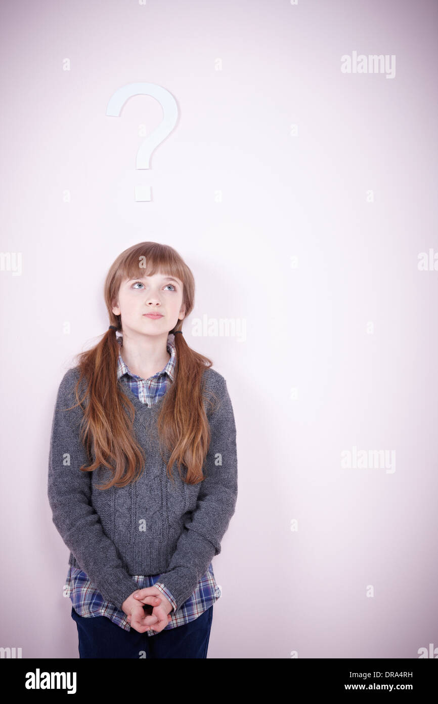 a girl standing under a question mark Stock Photo - Alamy