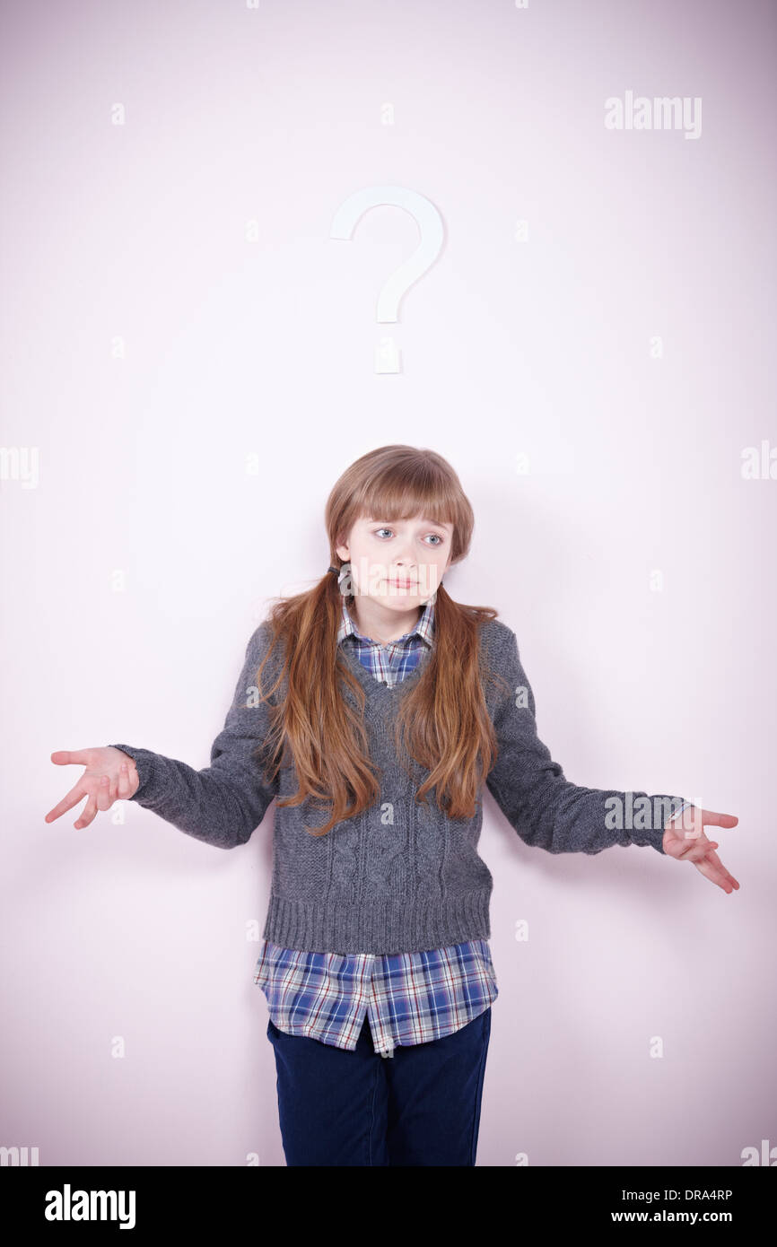 a girl standing under a question mark Stock Photo - Alamy