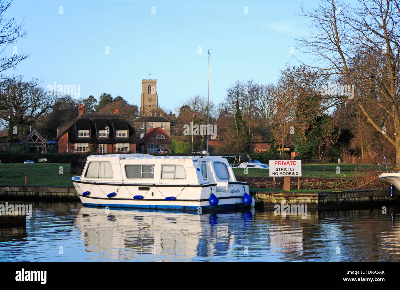 A view of a boat moored at Malthouse Broad with the church at Ranworth ...