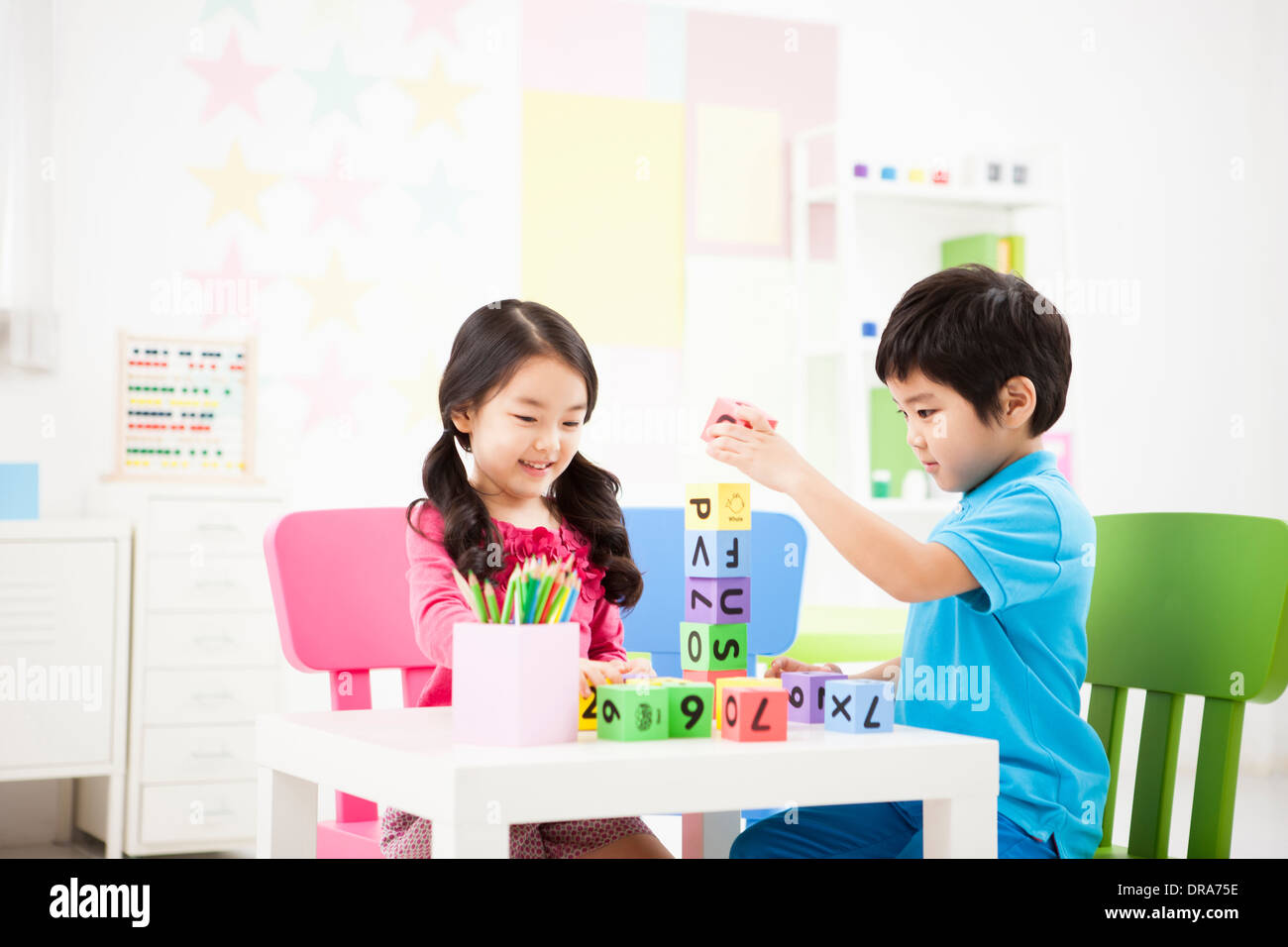 kids playing with toy cubes on a table Stock Photo - Alamy