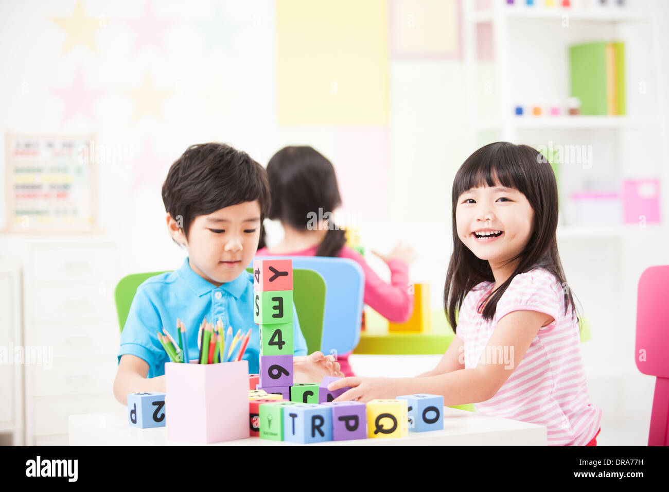 kids playing with toy cubes on a table Stock Photo - Alamy