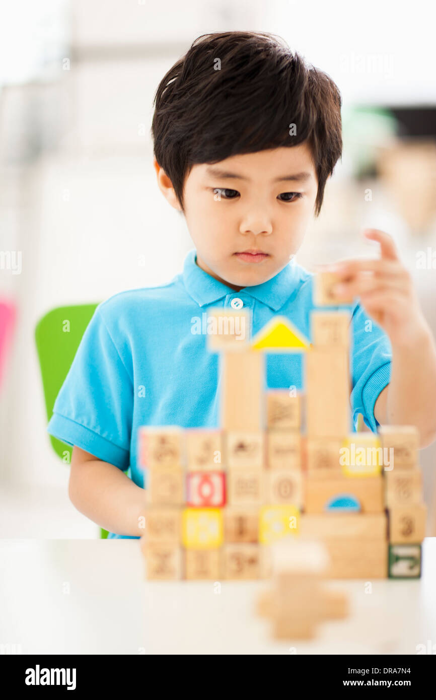 a boy building a castle with wood cubes Stock Photo - Alamy