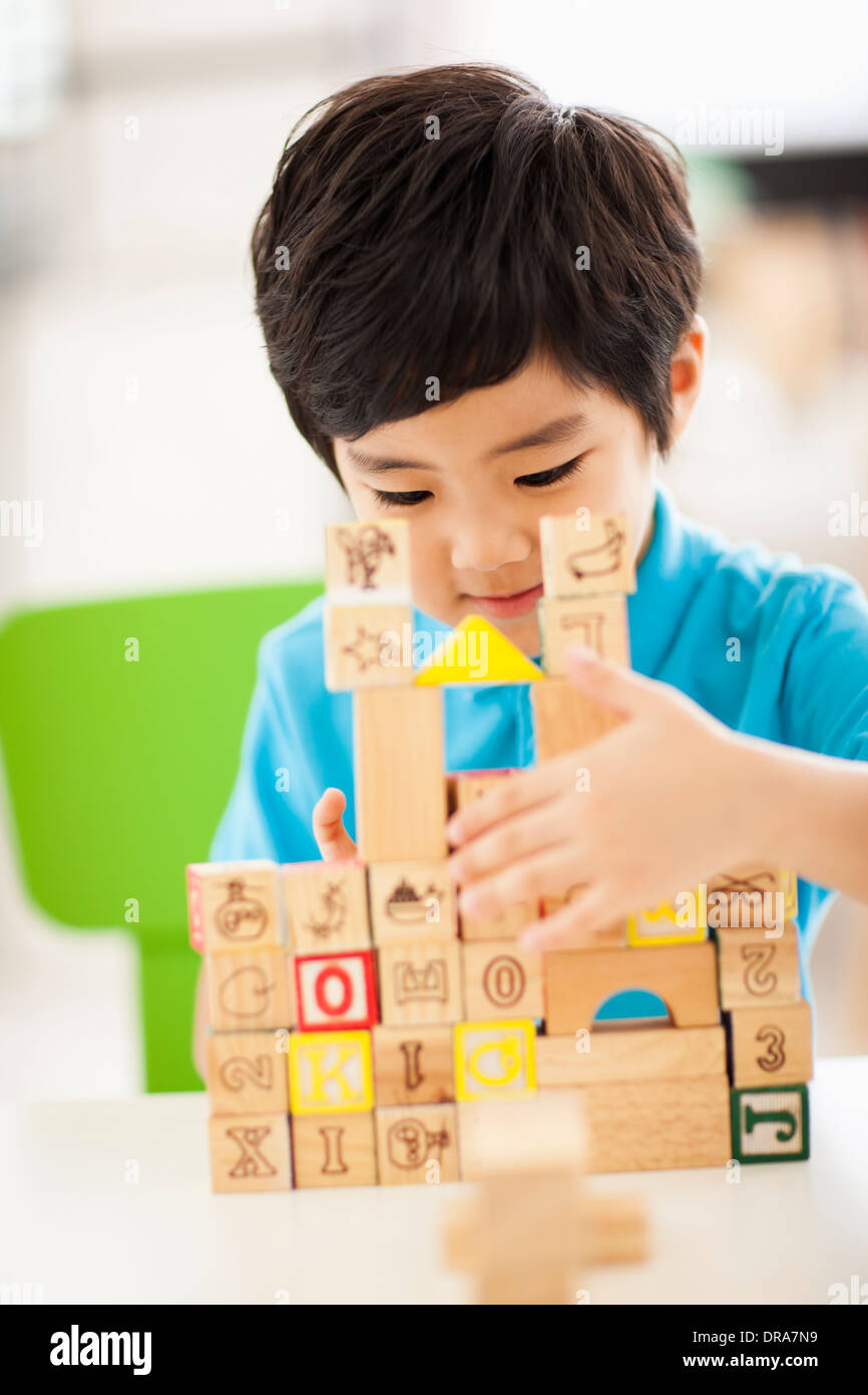 a boy building a castle with wood cubes Stock Photo - Alamy