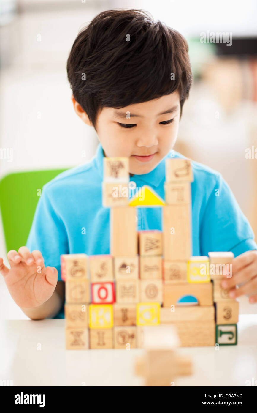a boy building a castle with wood cubes Stock Photo - Alamy
