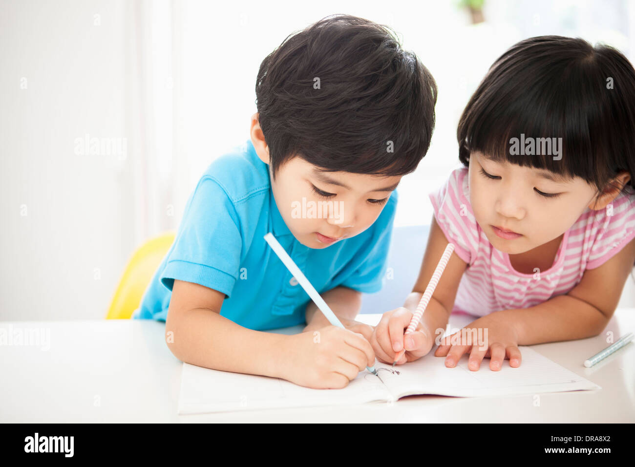 kids at desk learning together Stock Photo - Alamy