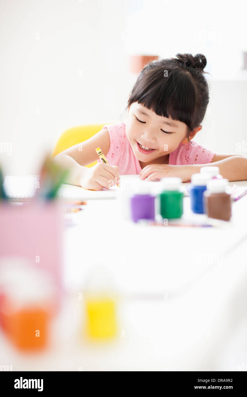 a girl drawing on a sketch book with crayon Stock Photo - Alamy