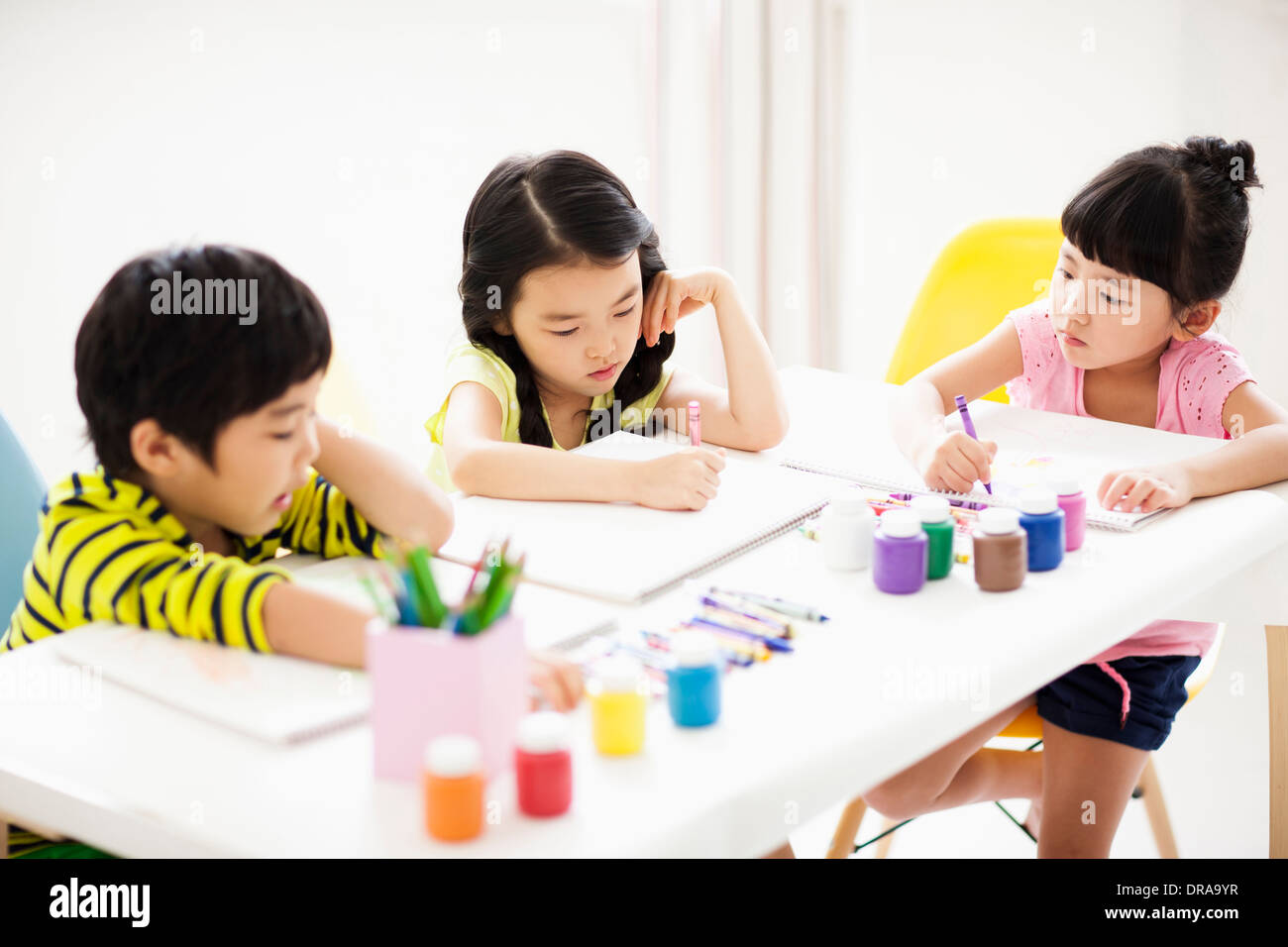 kids at table with sketchbooks and crayons Stock Photo - Alamy
