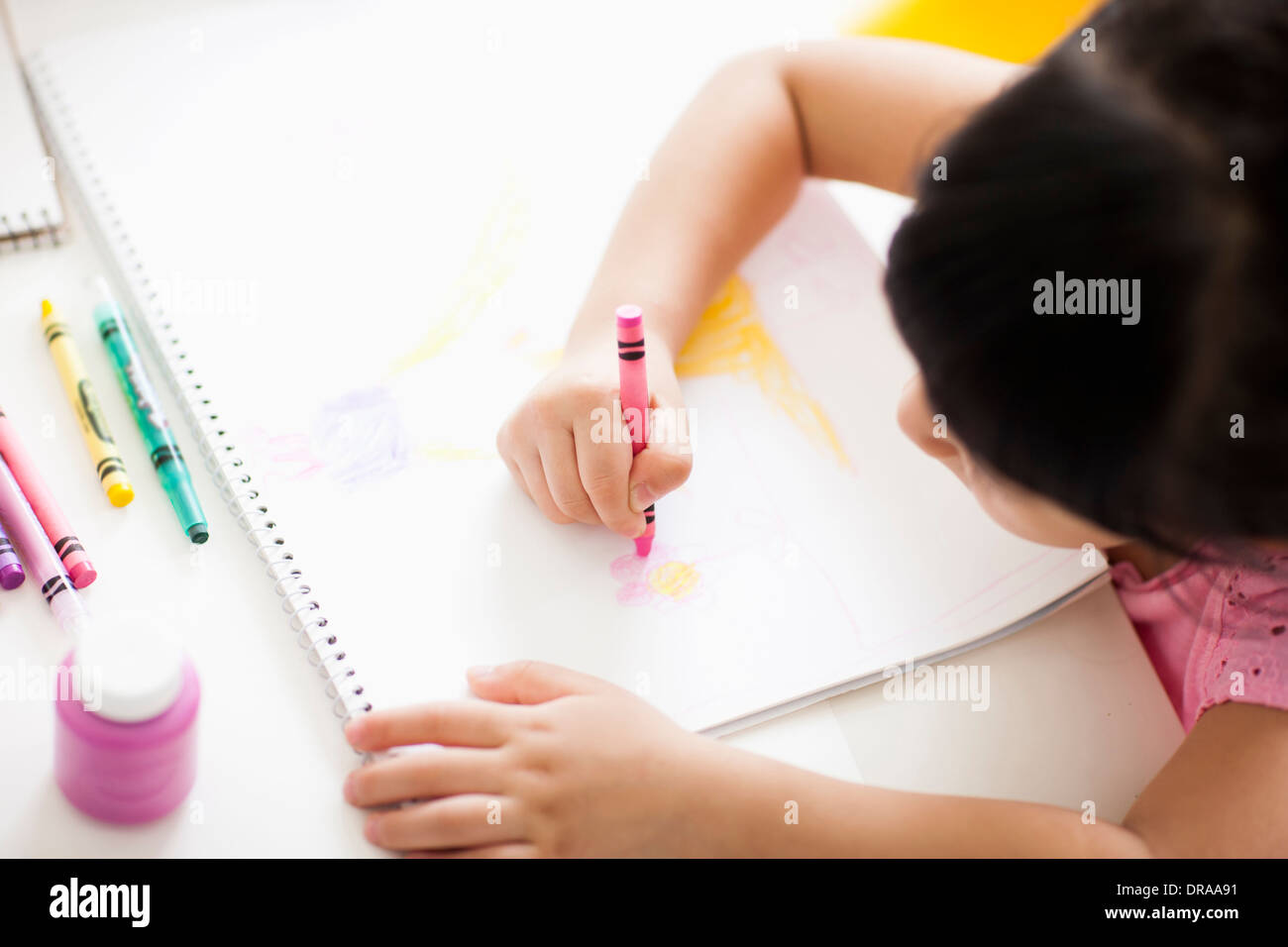 a girl drawing on a sketch book with crayon Stock Photo - Alamy