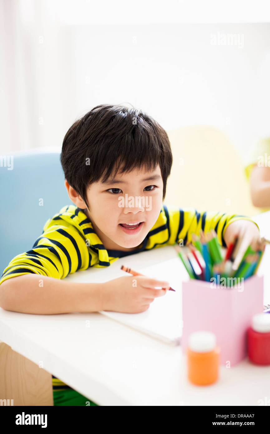 a boy drawing on a sketch book with crayon Stock Photo - Alamy