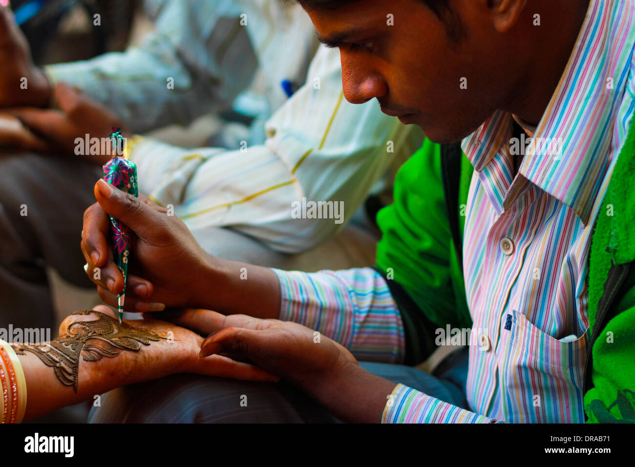 Man decorating woman's hand with henna Stock Photo - Alamy