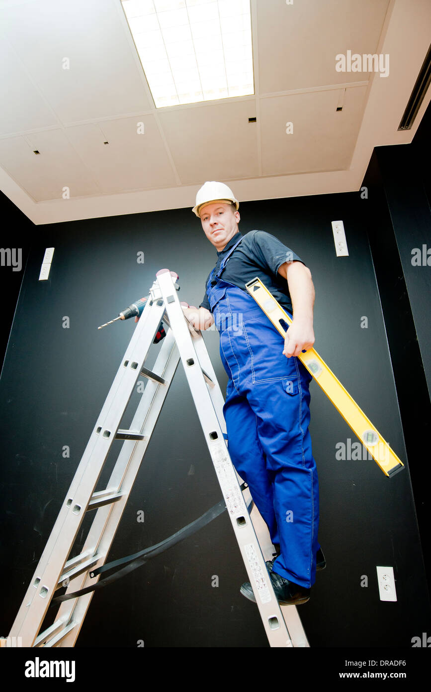 worker with tools, stands on a ladder Stock Photo - Alamy