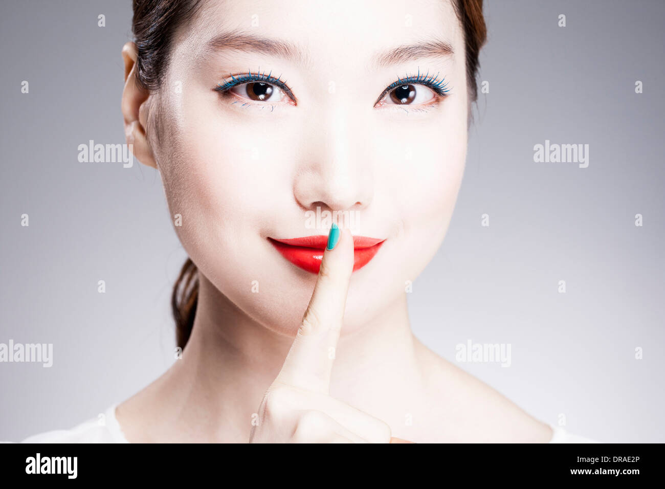 close up shot of a woman with a finger in her red lips Stock Photo - Alamy